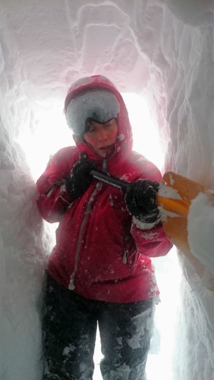Using a shovel to excavate the entrance tunnel of a snow hole ...
